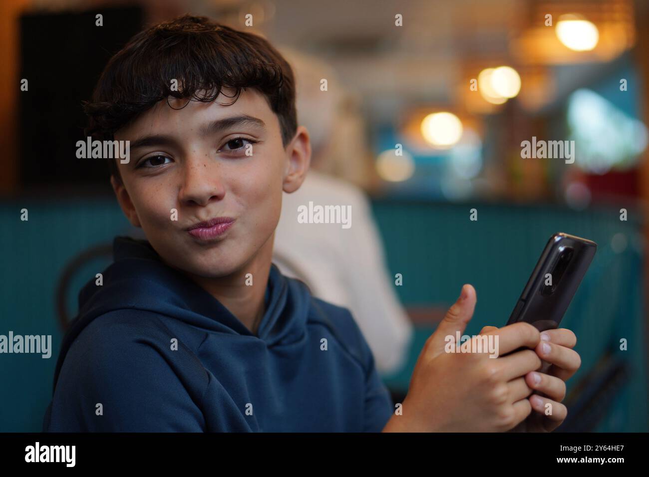teenage boy using cell phone making a face to the camera Stock Photo ...