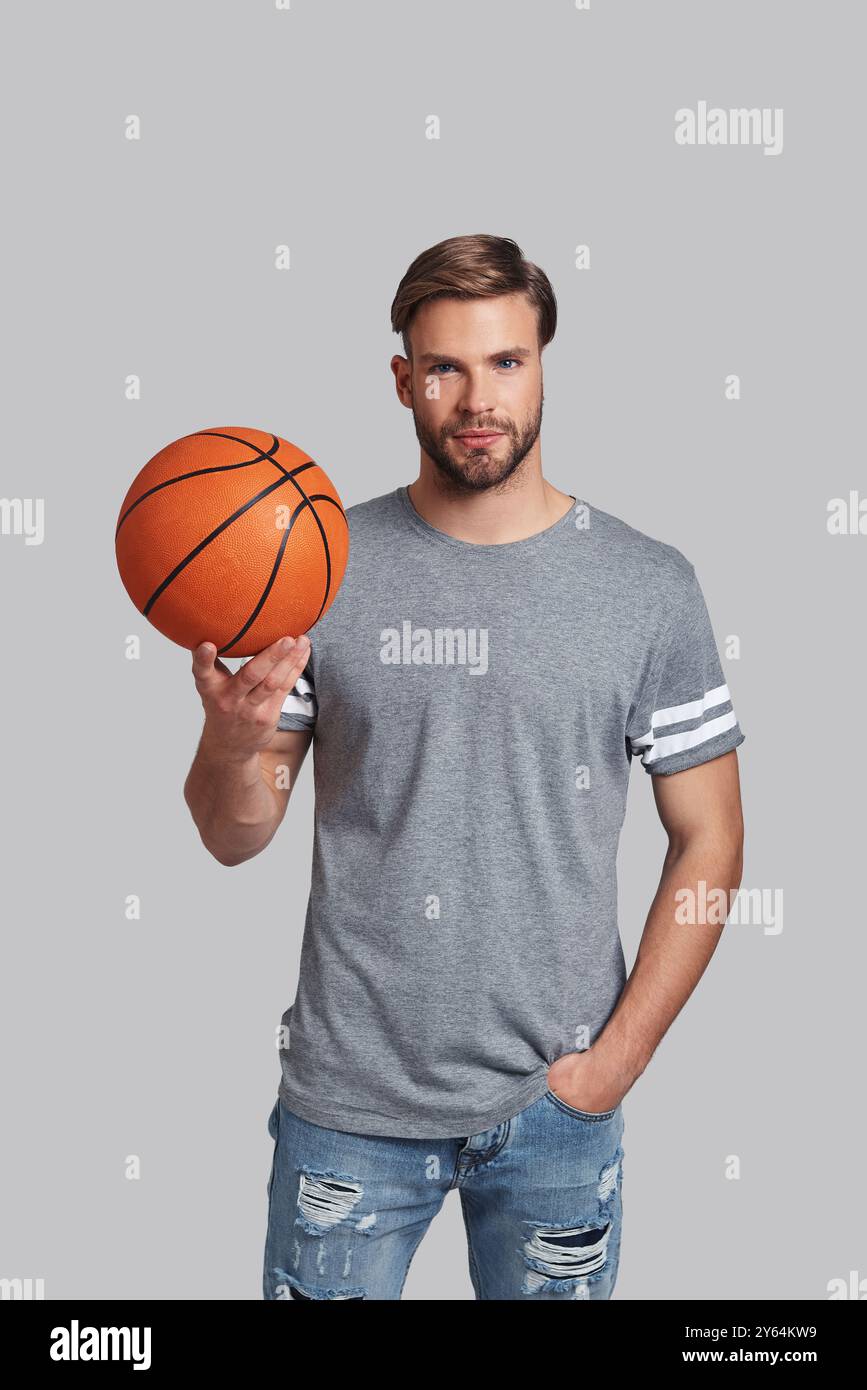 Are you ready to play? Handsome young man carrying a basketball ball ...