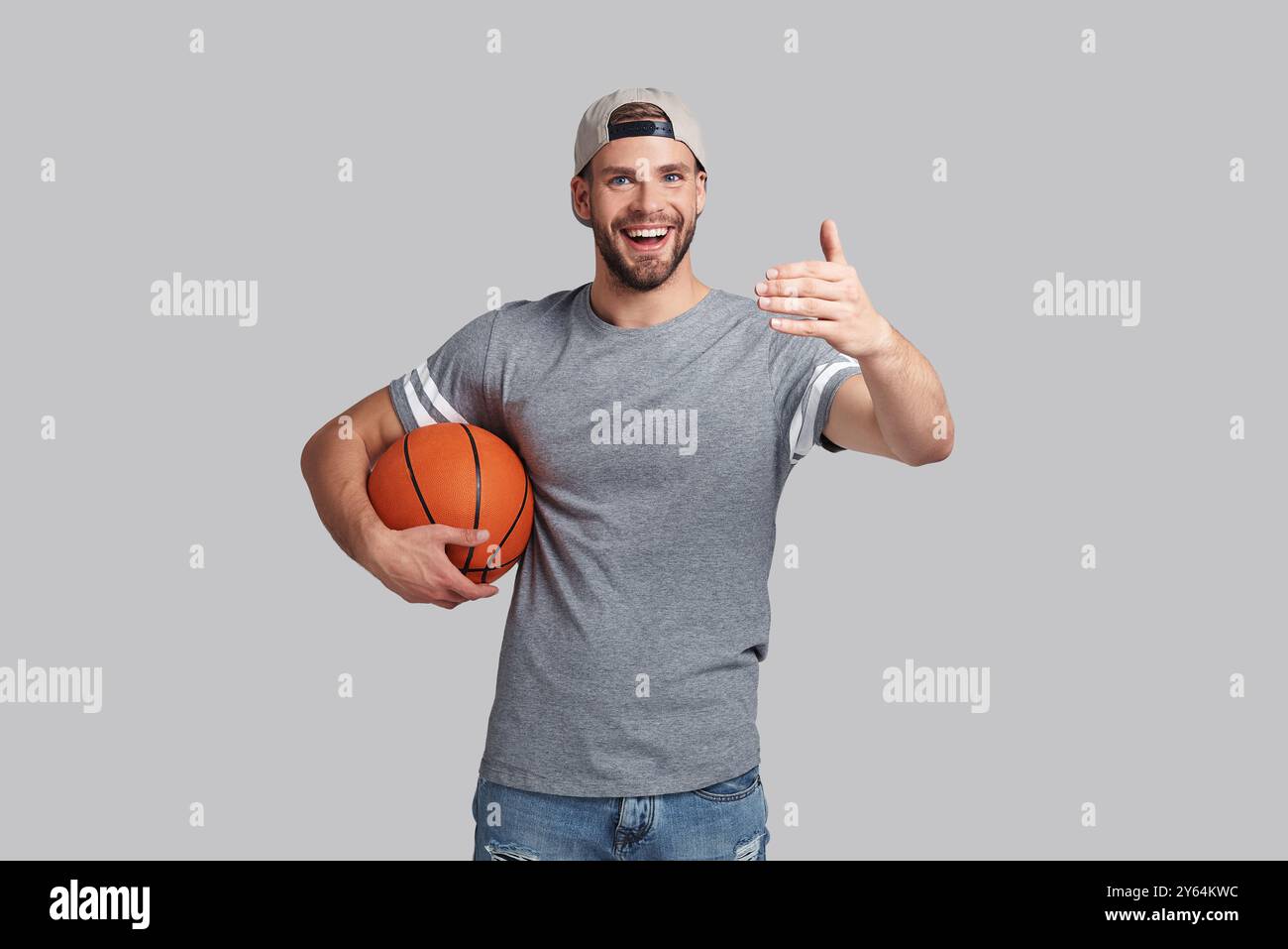 Always ready to win. Handsome young smiling man carrying a basketball ...