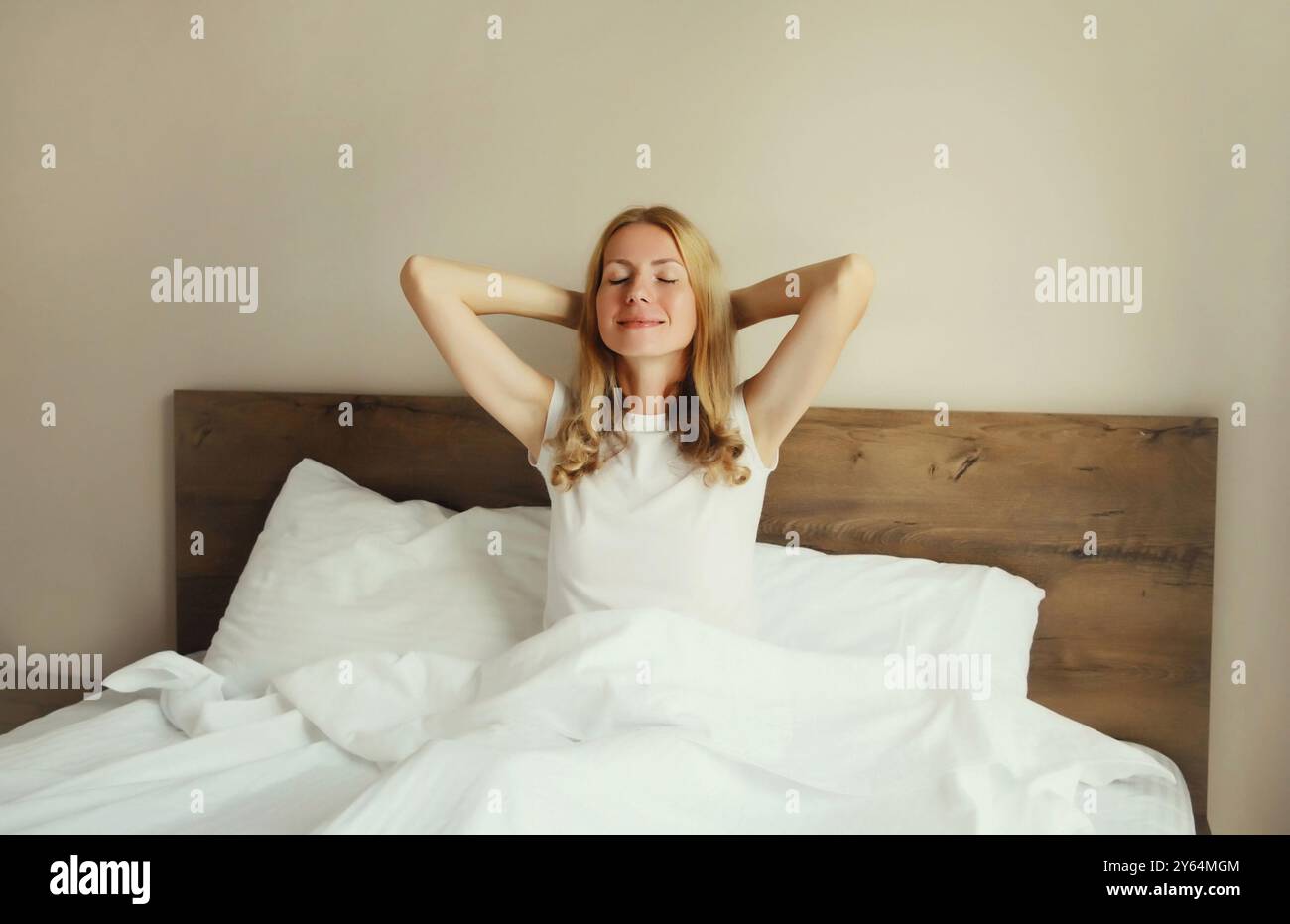Healthy sleep, relaxed woman wakes up lying on the bed in bedroom at ...