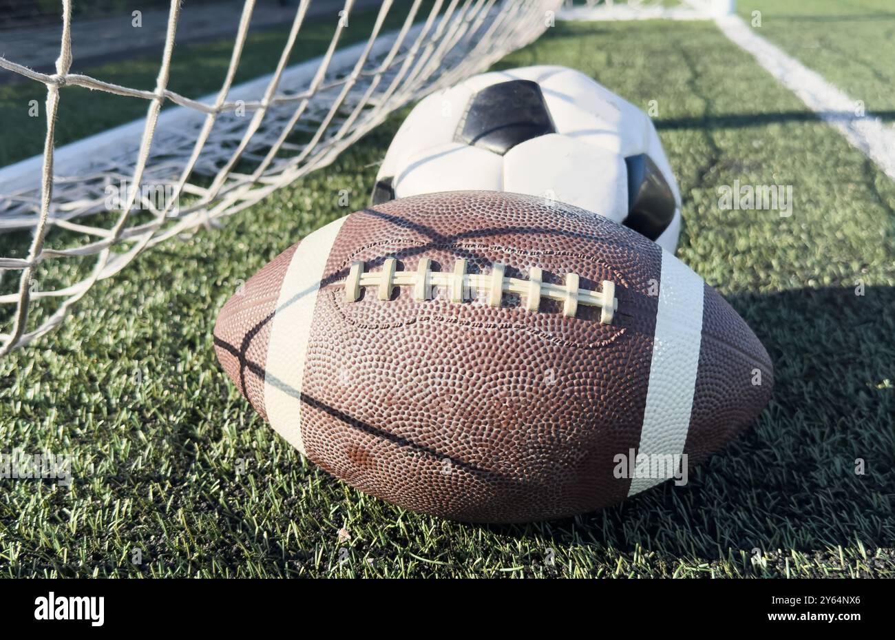 soccer ball and rugby ball, space for text Stock Photo - Alamy