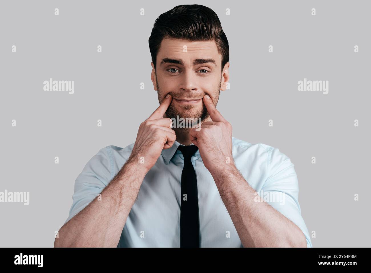 Nothing cheers him up. Sad young man in white shirt and tie trying to ...