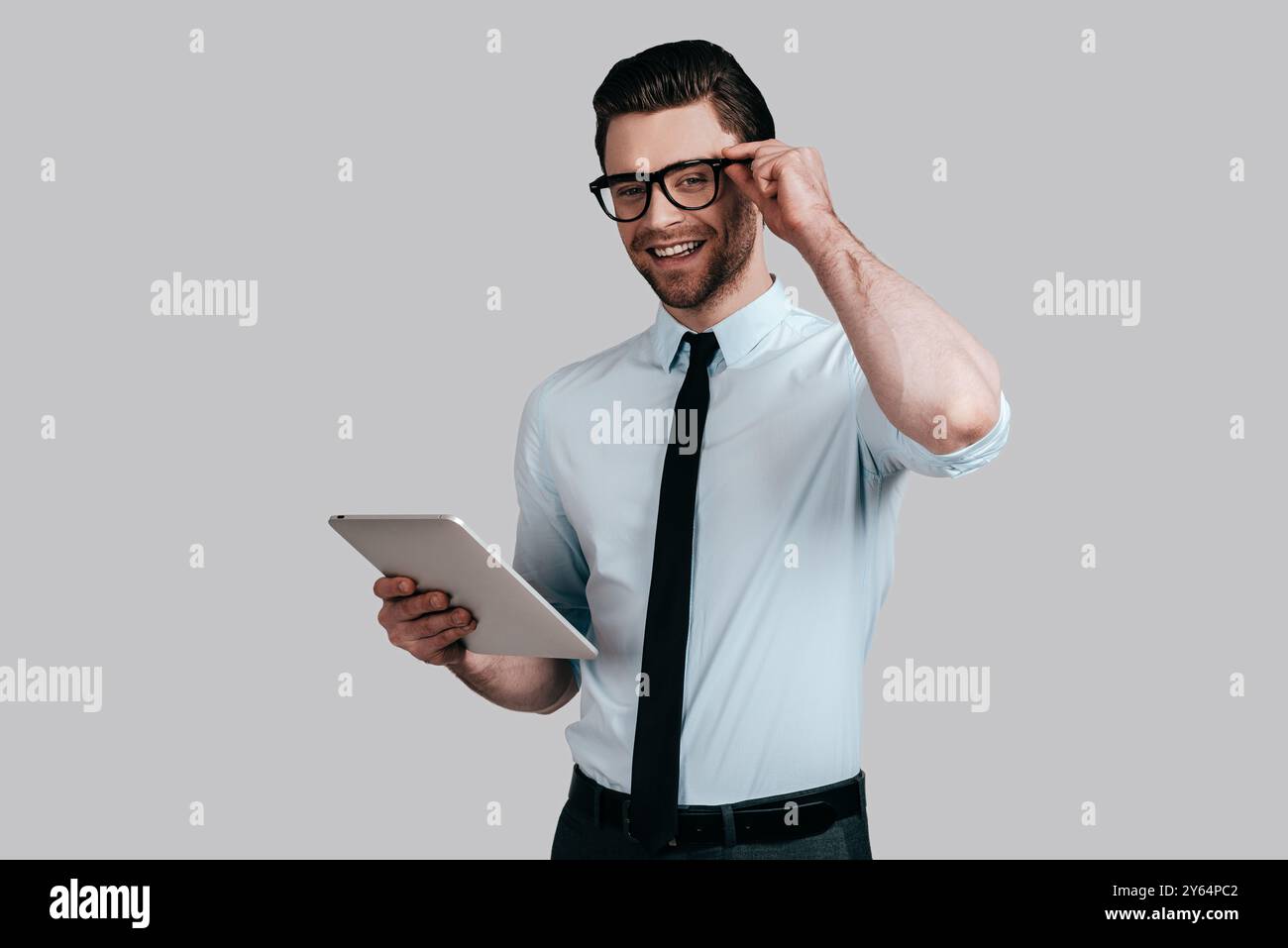 Always ready to help. Handsome young man in white shirt and tie holding ...