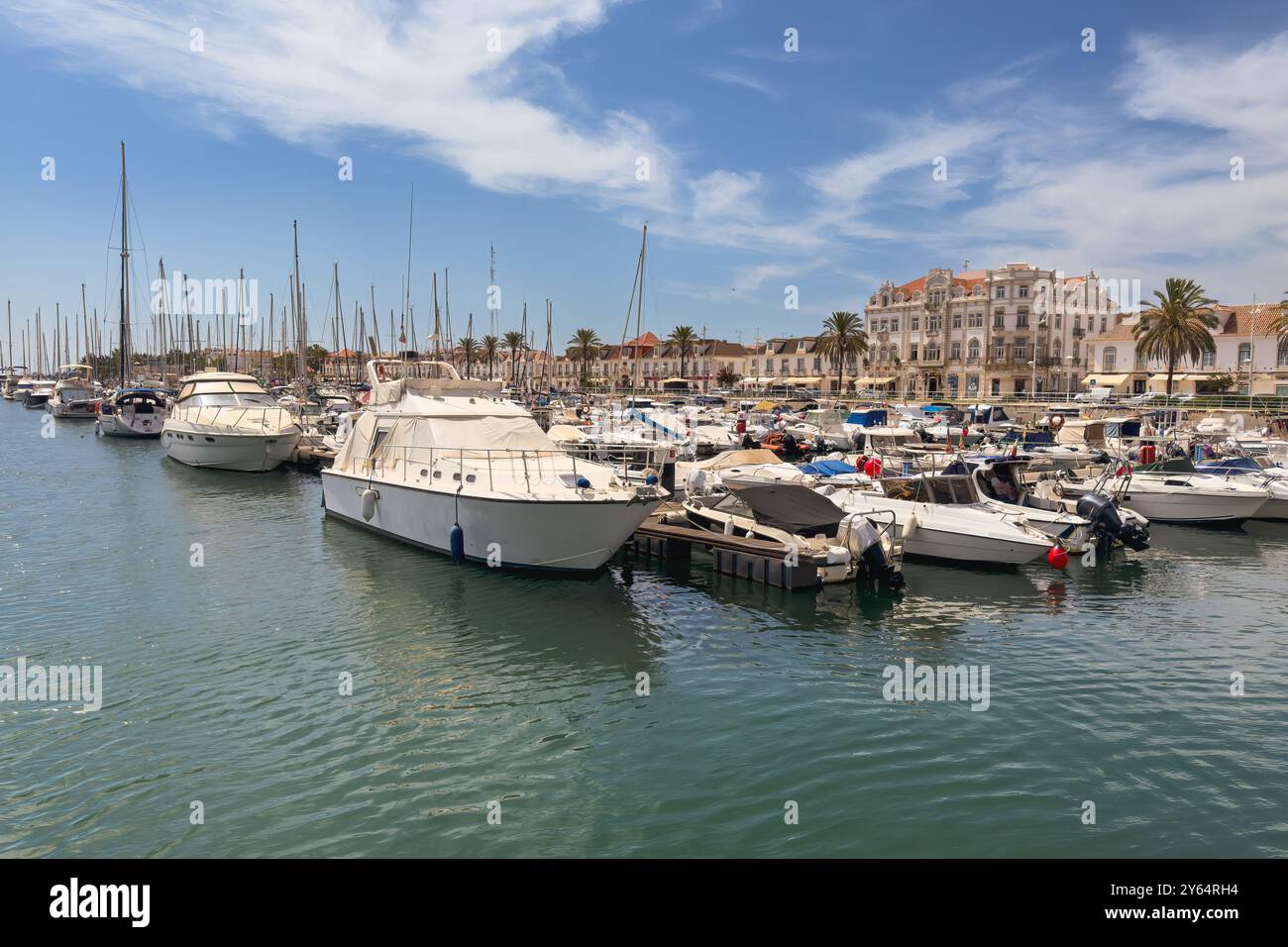 Sunny marina with docked boats and a scenic waterfront view Stock Photo ...