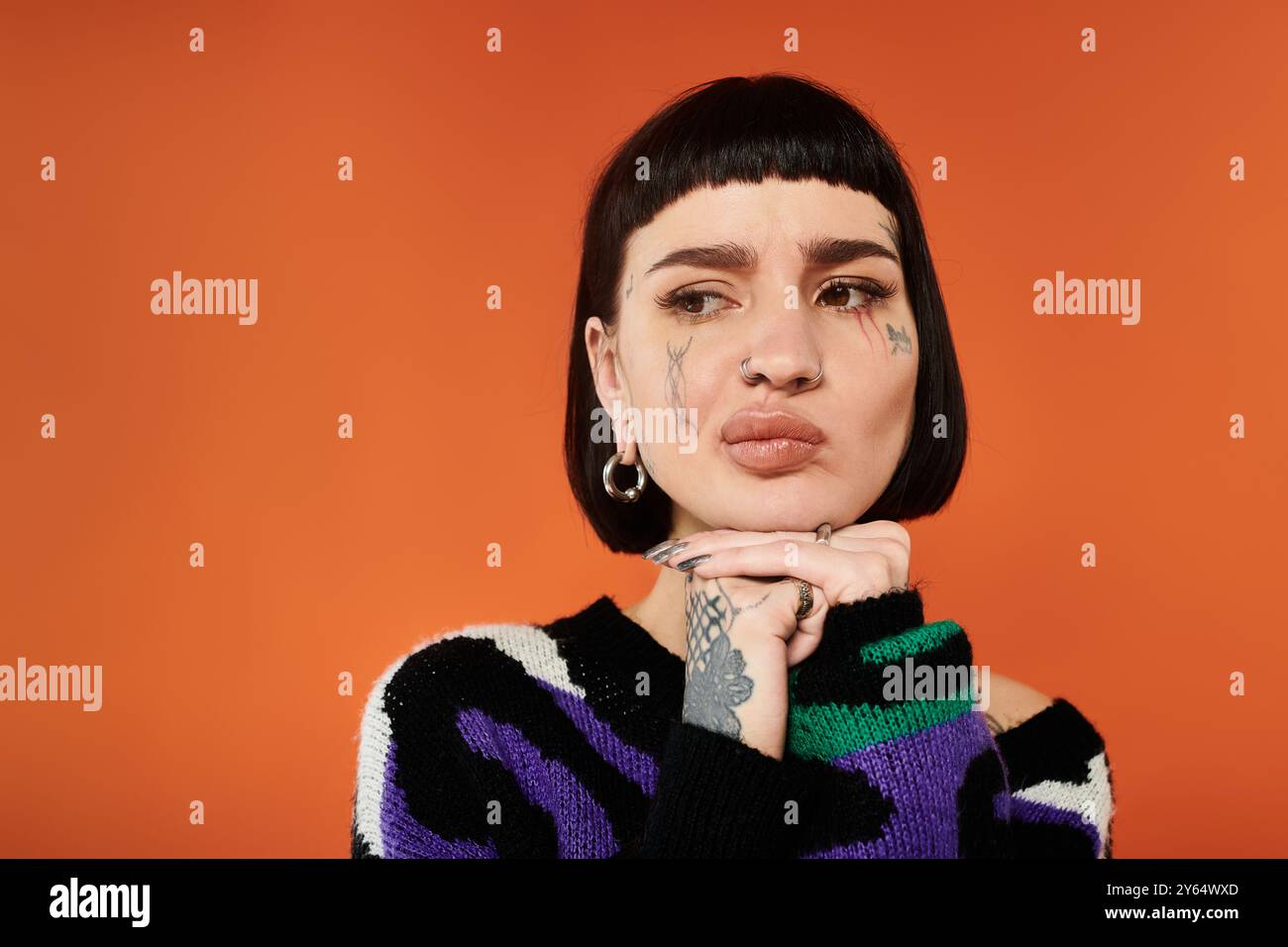 A young woman with a unique tattoo design and short hair models a ...