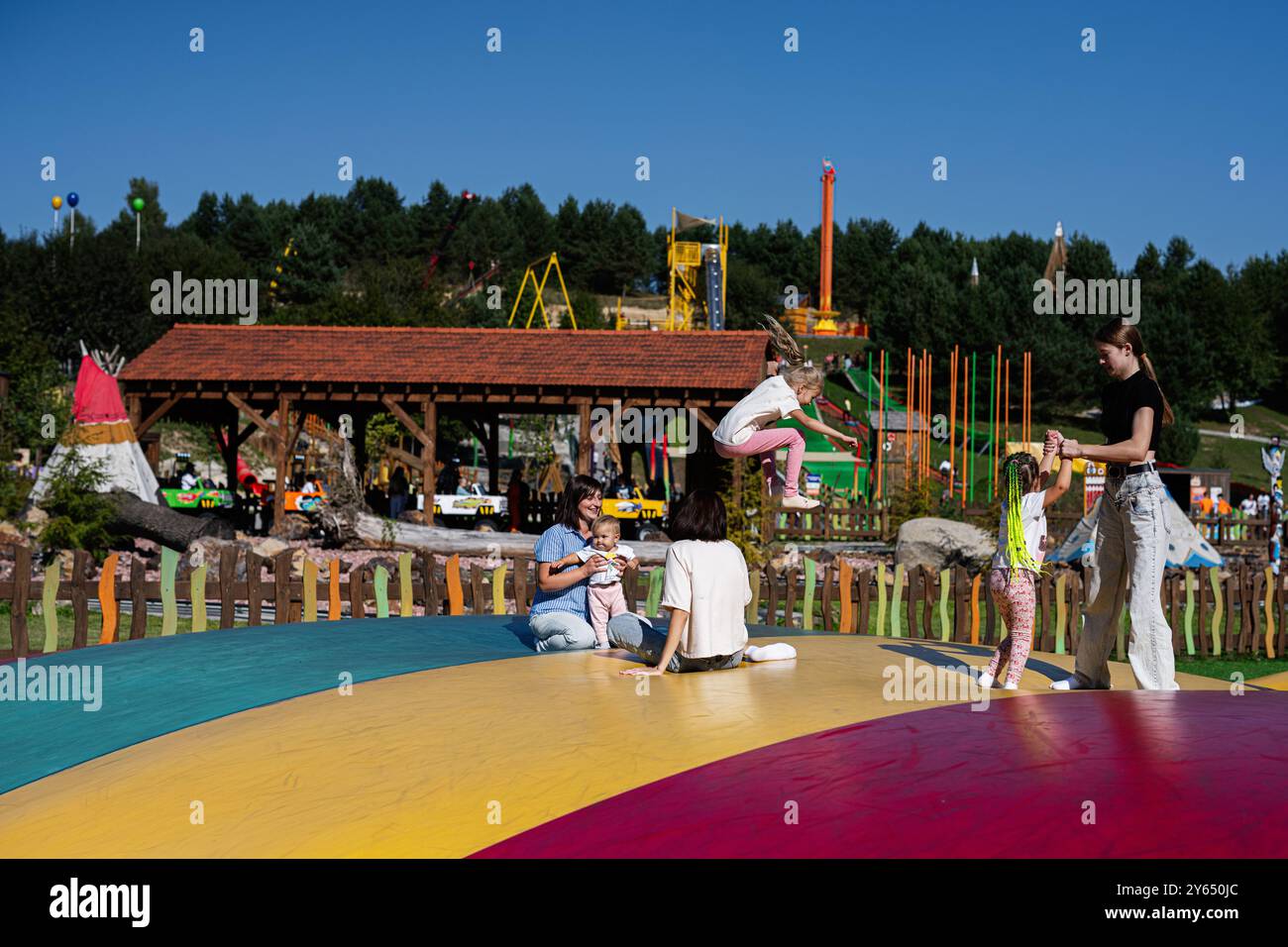 A lively scene at an amusement park featuring children playing and ...