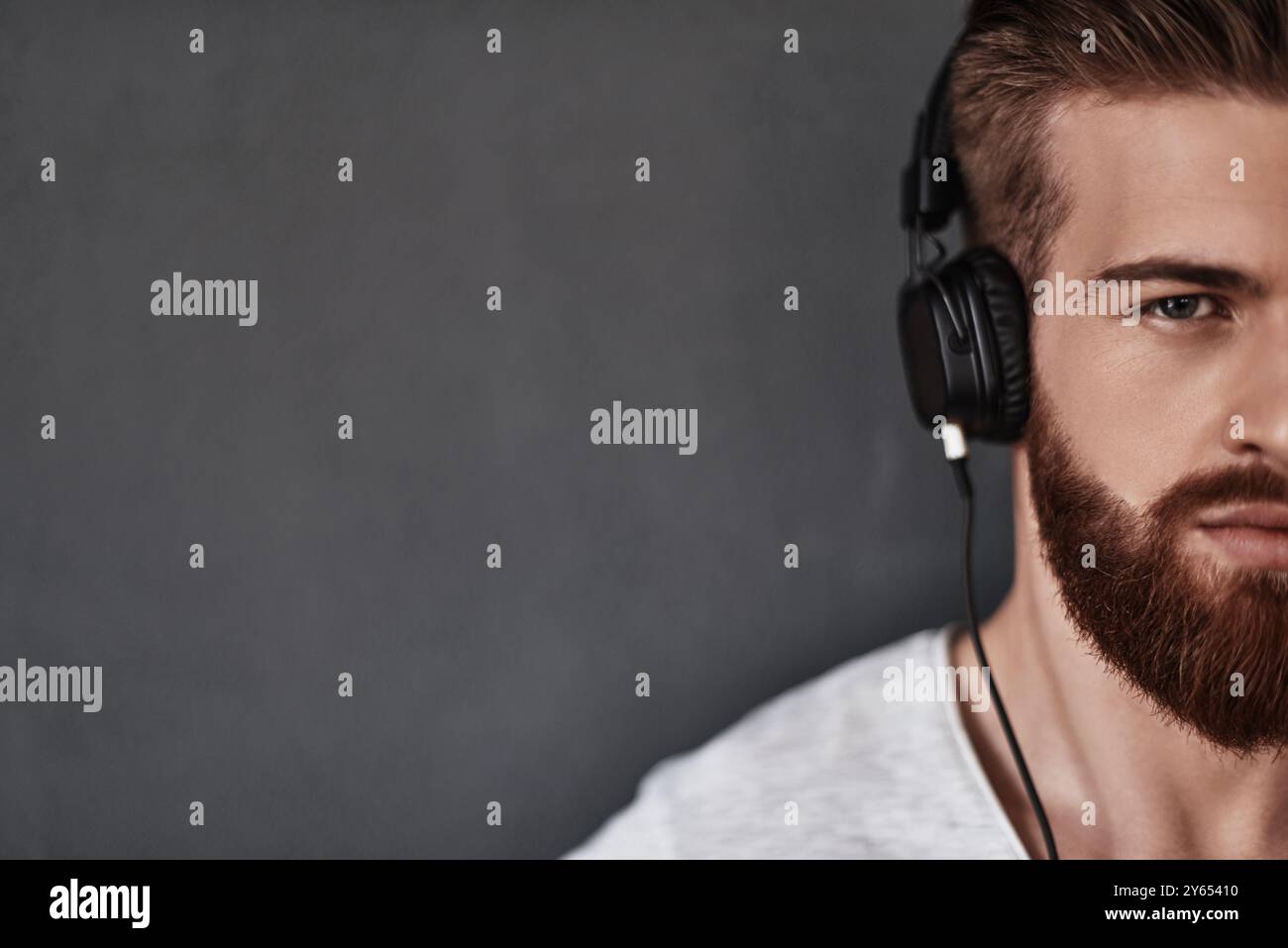 Music is his motivation. Close up of good looking young man half face ...
