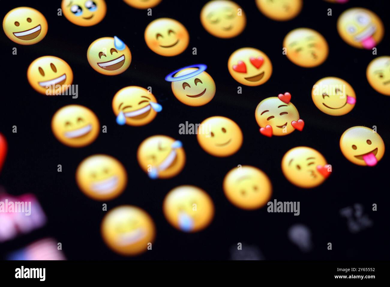 Verschiedene Emojis auf einem Smartphone Display. Mit Emojis kann man in Textnachrichten seine ...