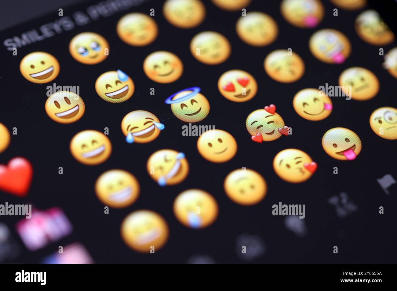Verschiedene Emojis auf einem Smartphone Display. Mit Emojis kann man in Textnachrichten seine ...