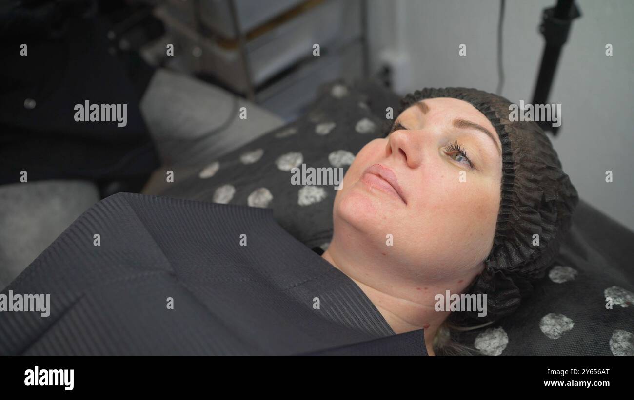Vertical video. The model lies on the couch in the beauty salon. A ...