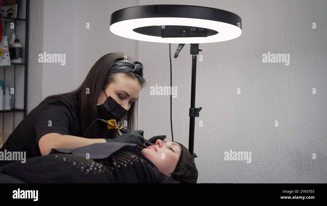 The procedure of permanent lip makeup in the beauty salon ...