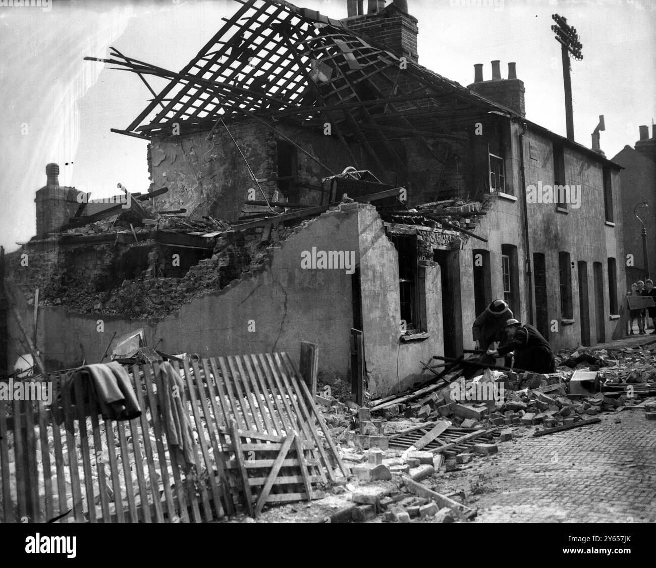 A fireman and an ARP warden sifting through the debris of bombed ...
