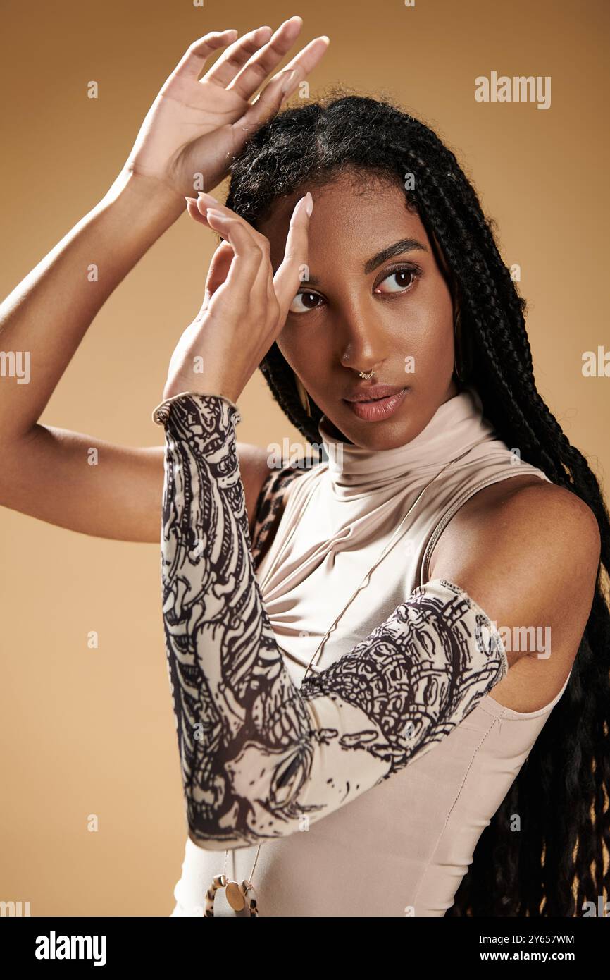 A beautiful young woman in trendy attire elegantly poses, highlighting ...