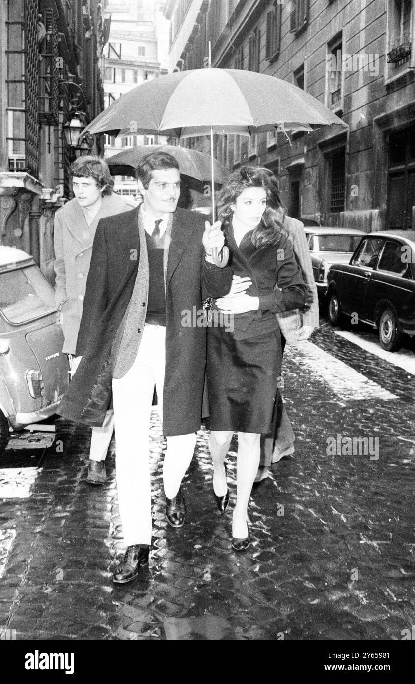 Omar Sharif and French star Anouk Aimee stroll in the rain along the ...