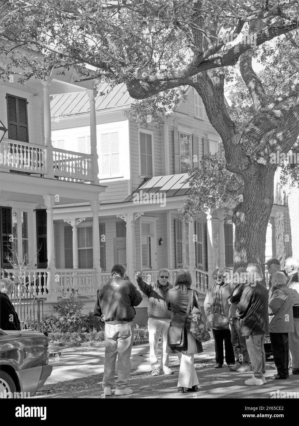 Group of tourists listening to a tour guide while viewing historic ...