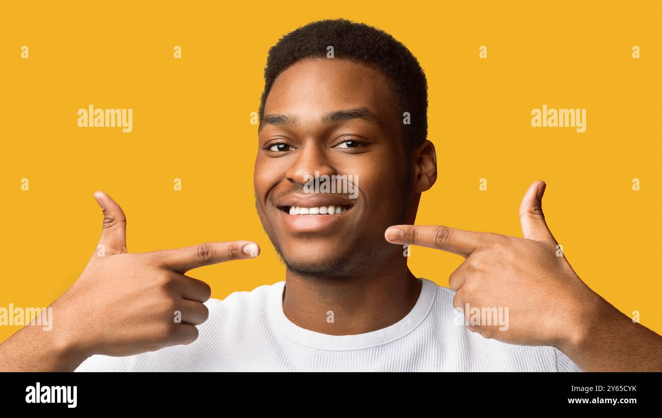 Afro guy smiling and showing perfect healthy teeth Stock Photo - Alamy