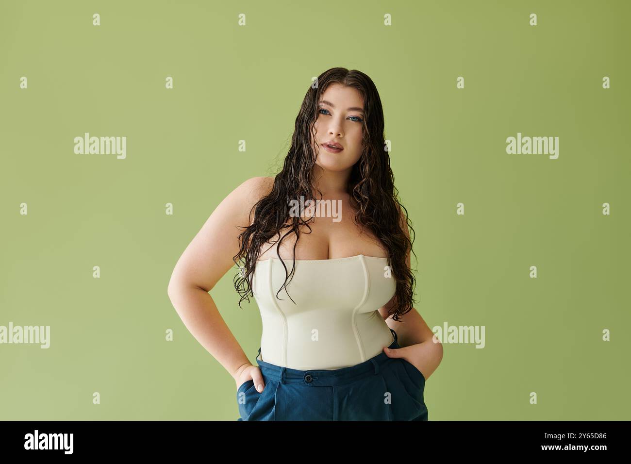 A young, beautiful plus size woman with curly hair displays her ...