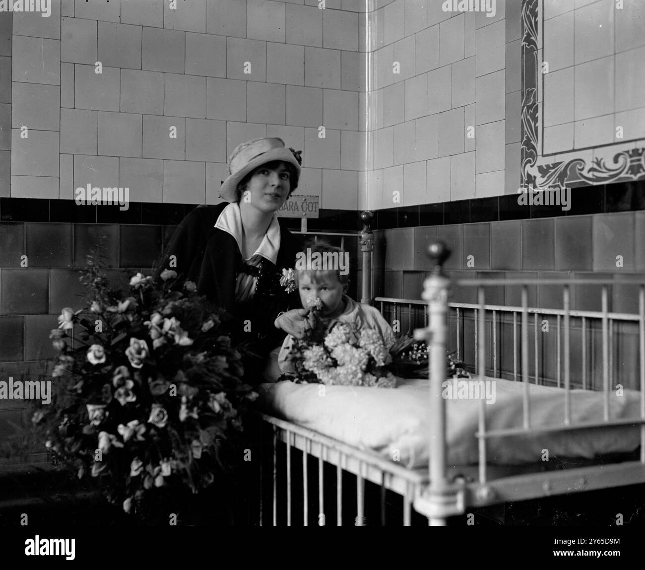 The famous actress , Miss Ina Claire , takes flowers to patients of the ...