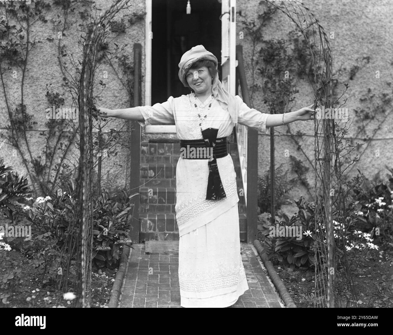 Miss Marie Lloyd , the famous music hall singer , poses in her garden ...