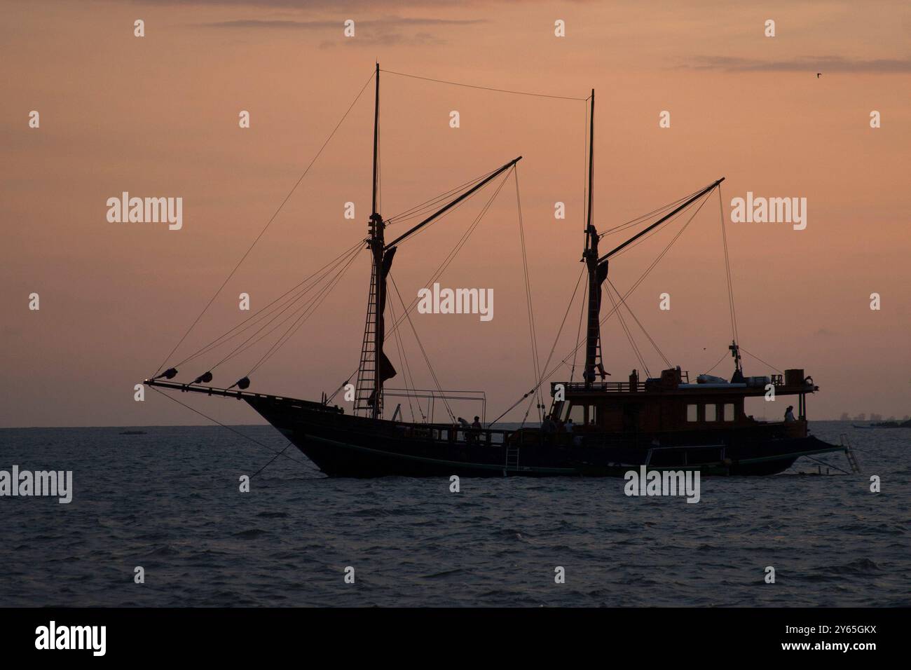 silhouette phinisi wooden ship at sunset, a traditional wooden boat ...
