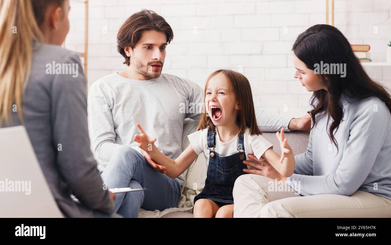 Shocked parents soothing their screaming little daughter at ...