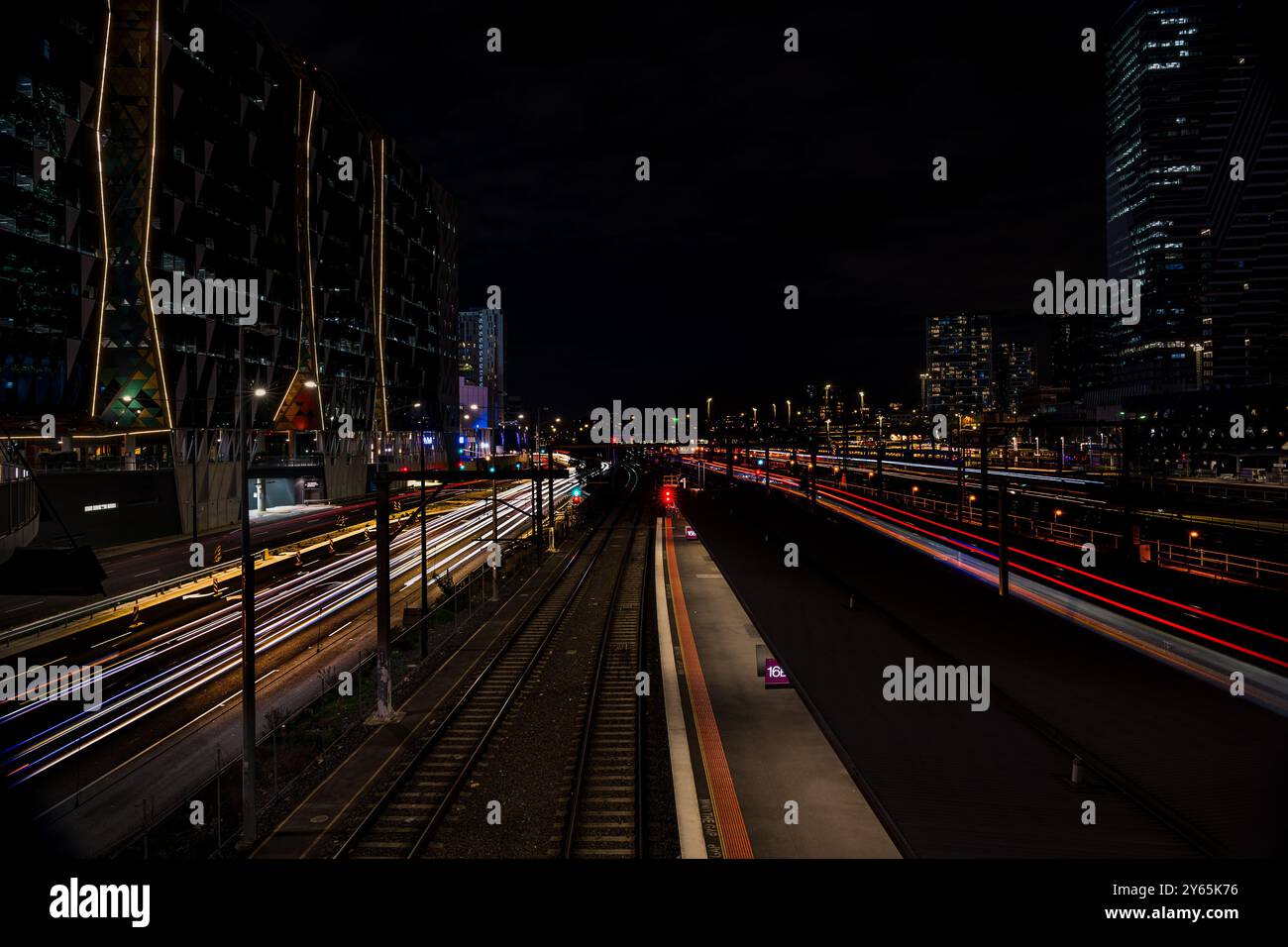 Traffic light trails on Wurundjeri Way and train track outside the ...