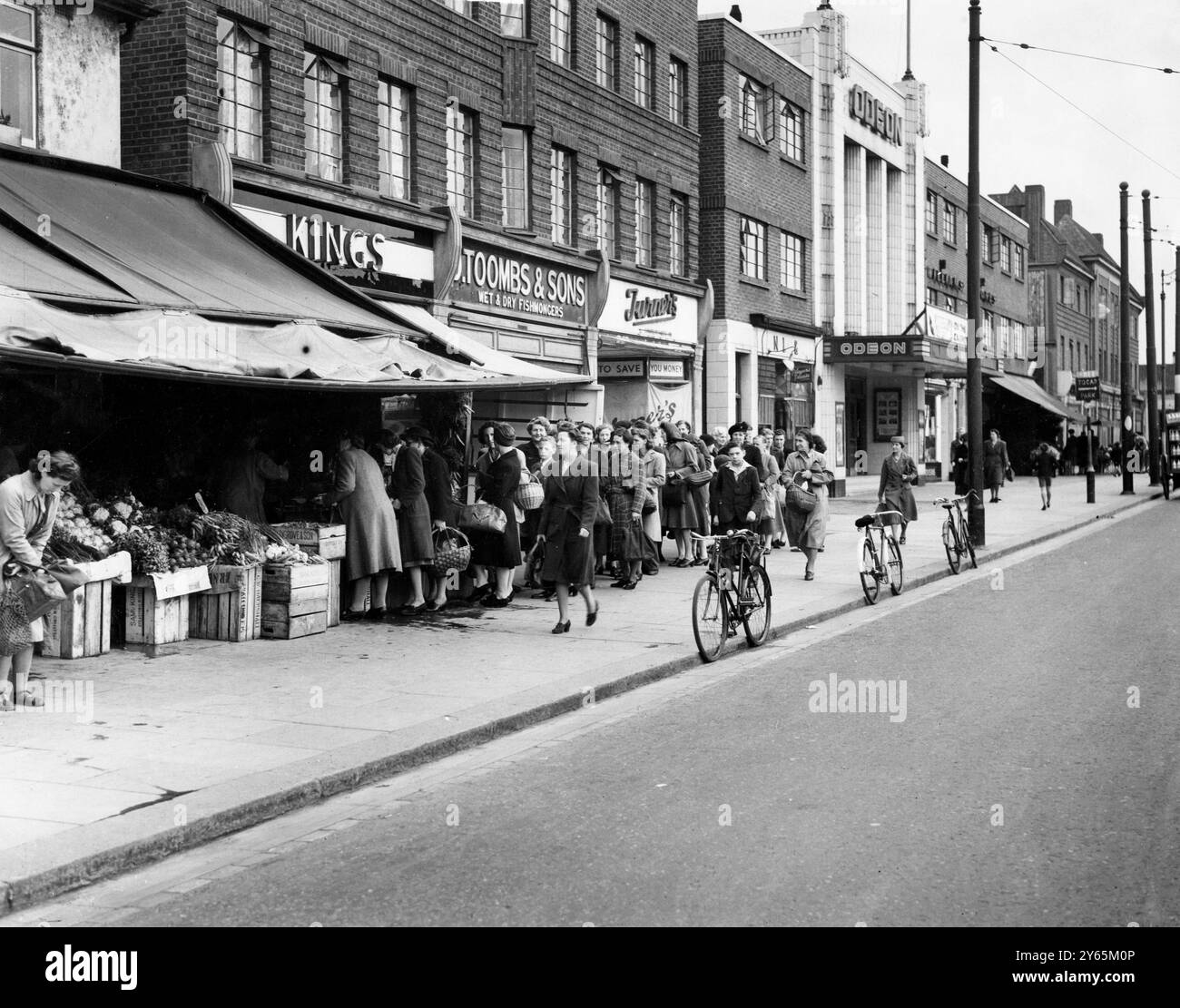 The high street in Bexleyheath , Kent , with shoppers queuing for bread ...