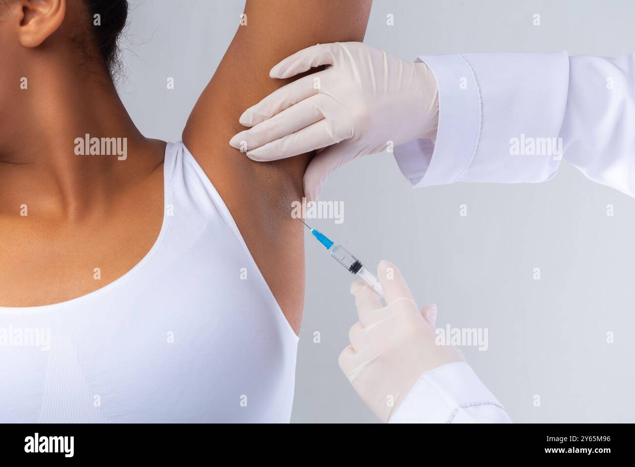 Doctor makes intramuscular injections of botulinum toxin in underarm ...
