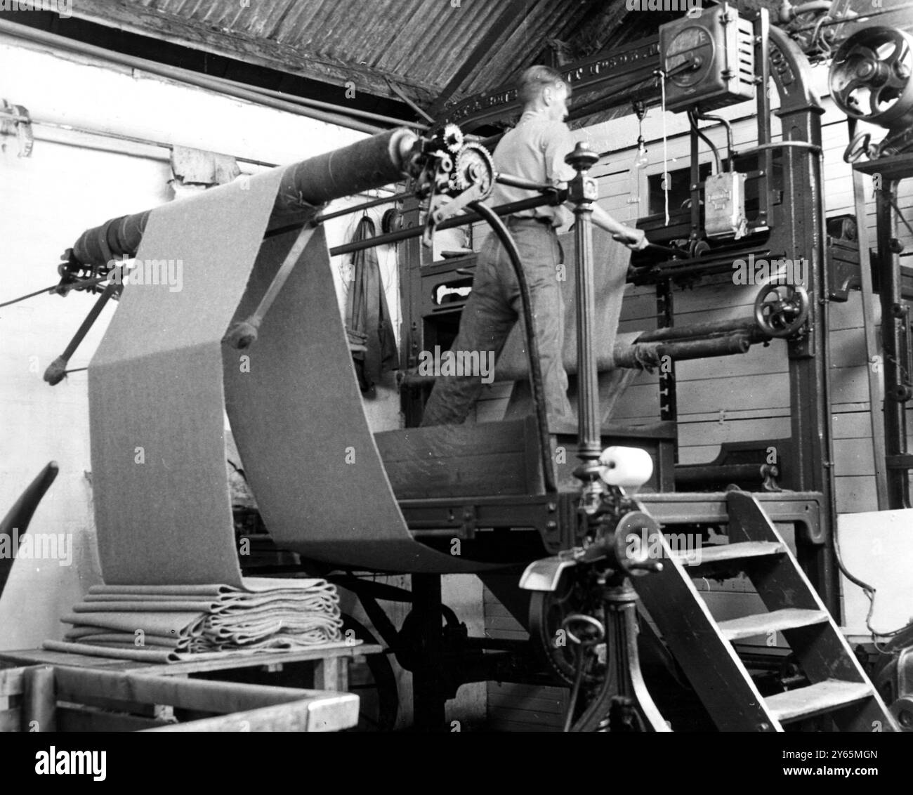 Harris Tweed manufacture . The finished cloth on the mechanical loom ...