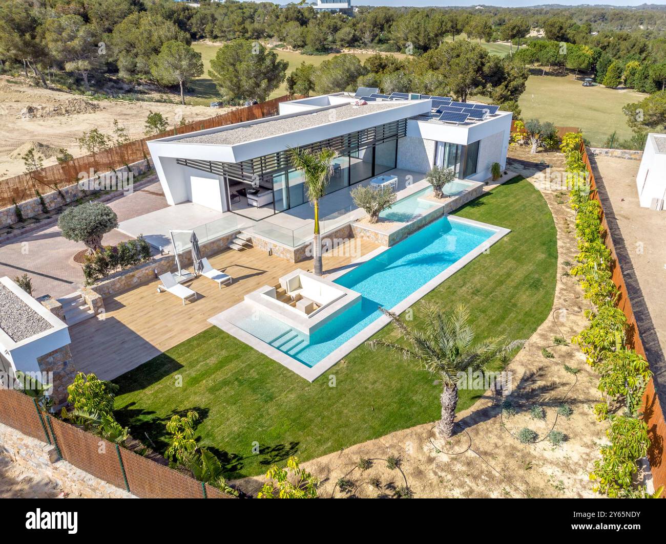 Aerial shot capturing a modern white Mediterranean villa surrounded by ...