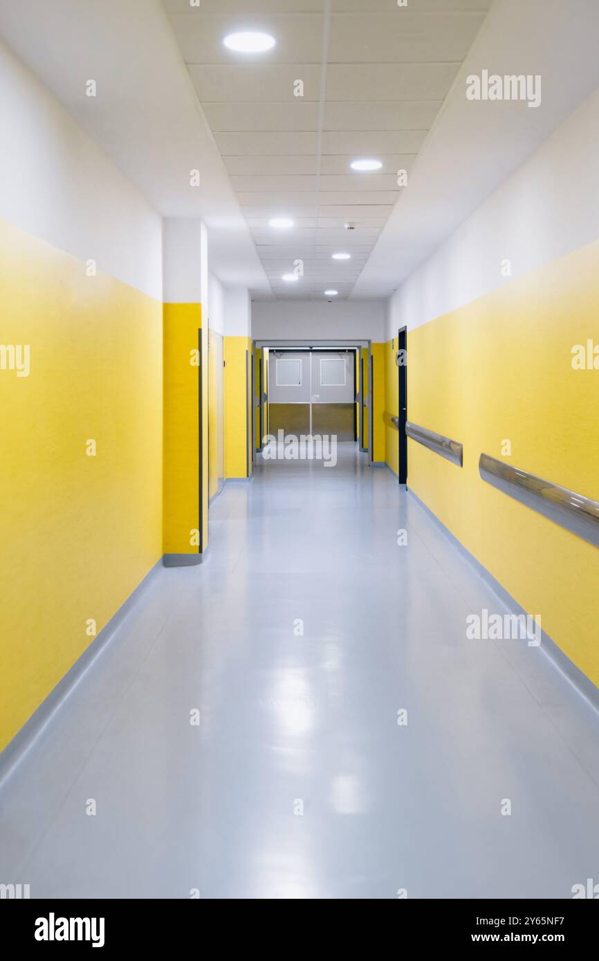 A photograph showcasing a bright, sterile hospital corridor painted in ...
