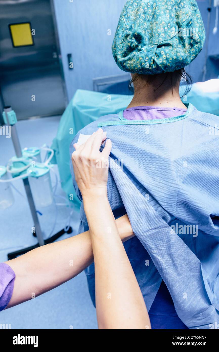 A patient in surgical attire prepares for an operation, with a medical ...