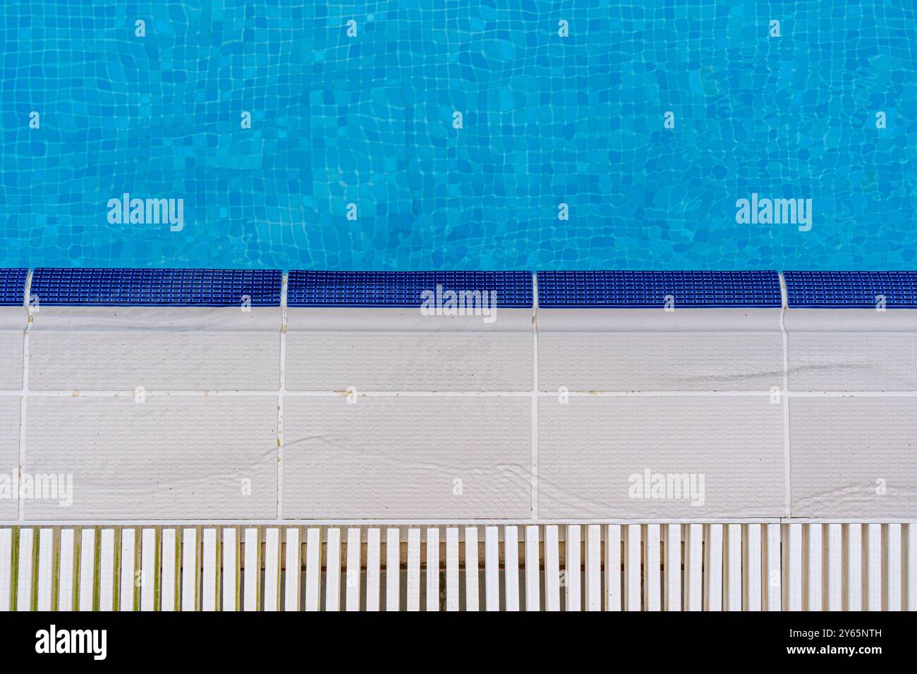 Overhead view of a clean swimming pool with clear blue water, bordered ...