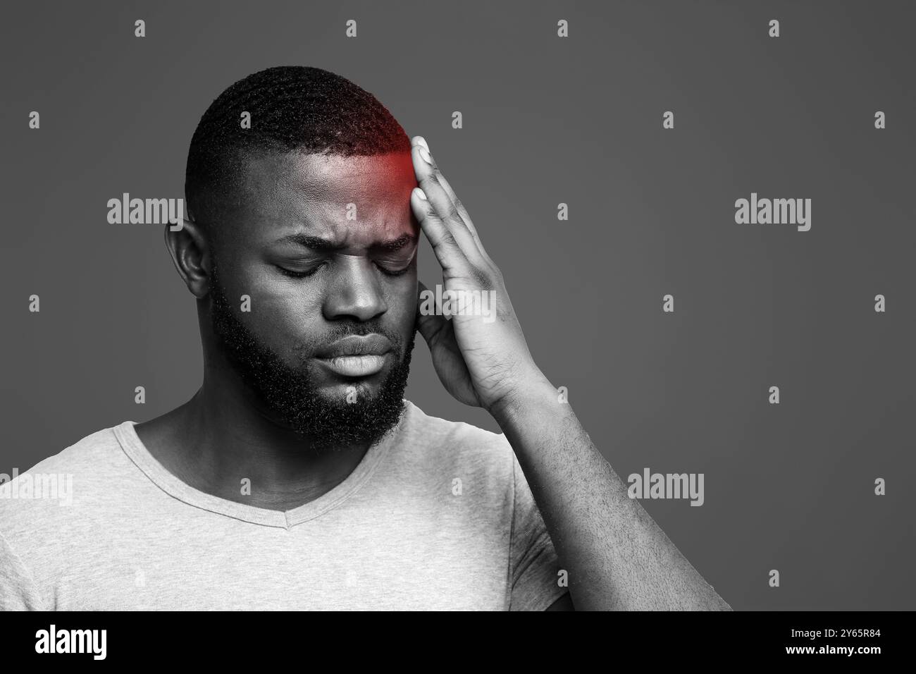 Young man suffering from headache, touching forehead Stock Photo - Alamy