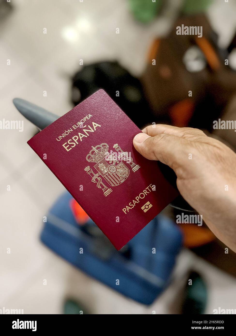 Cropped and unrecognizable person holding a Spanish passport at the ...