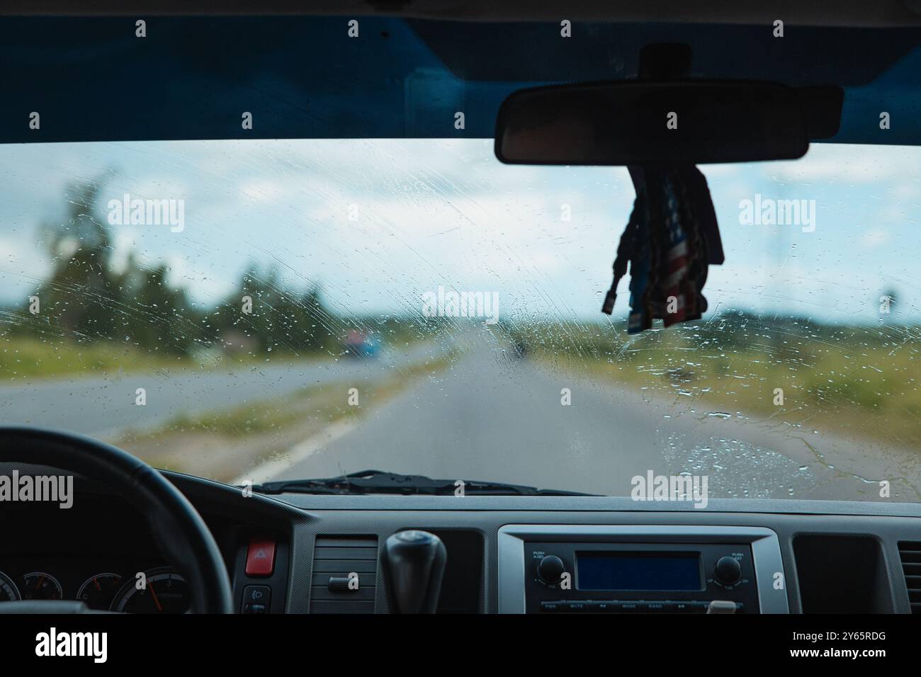 Inside view of a car journeying on a wet road under a rain-swept ...