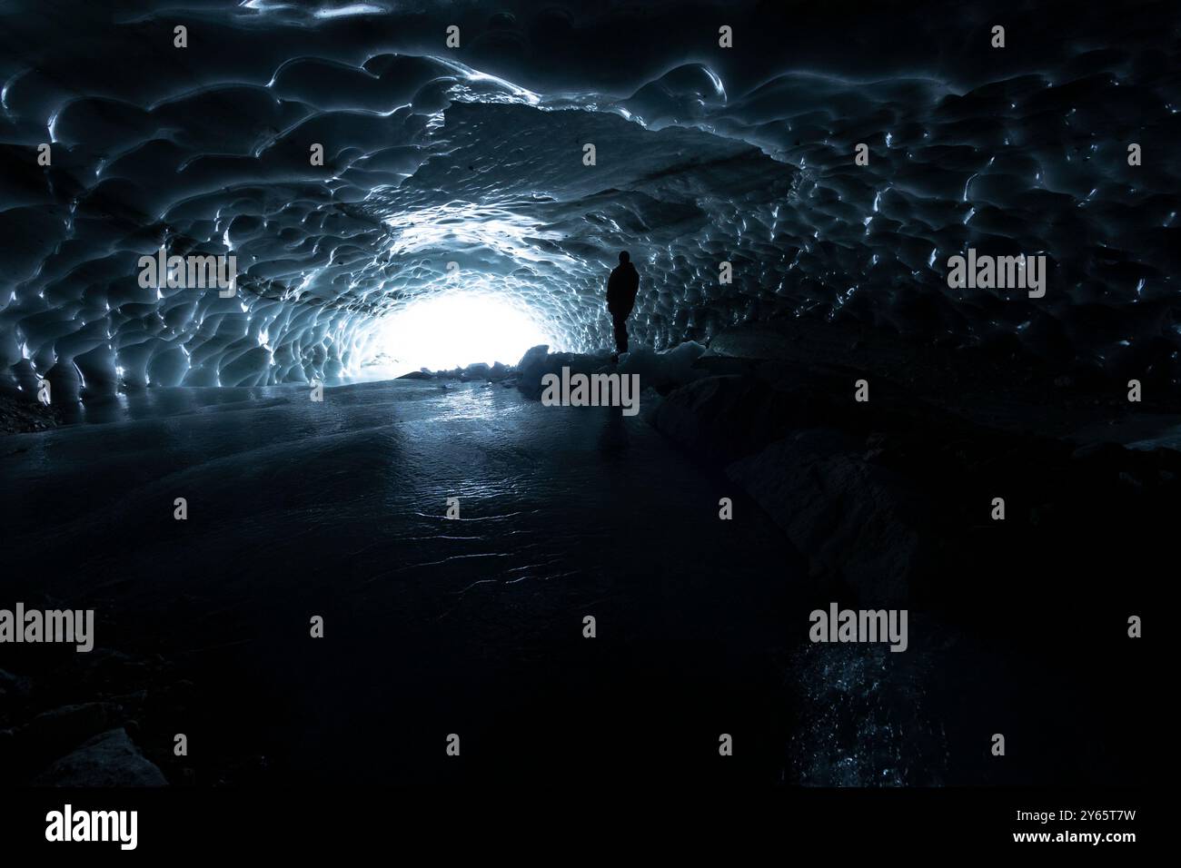 A cavernous ice cave illuminated by natural light showcasing intricate ...