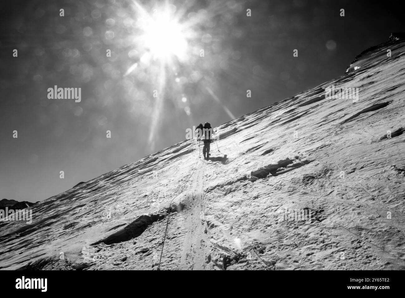 Two adventurers brave the snowy climb to Bishorn Peak, the sun shining ...