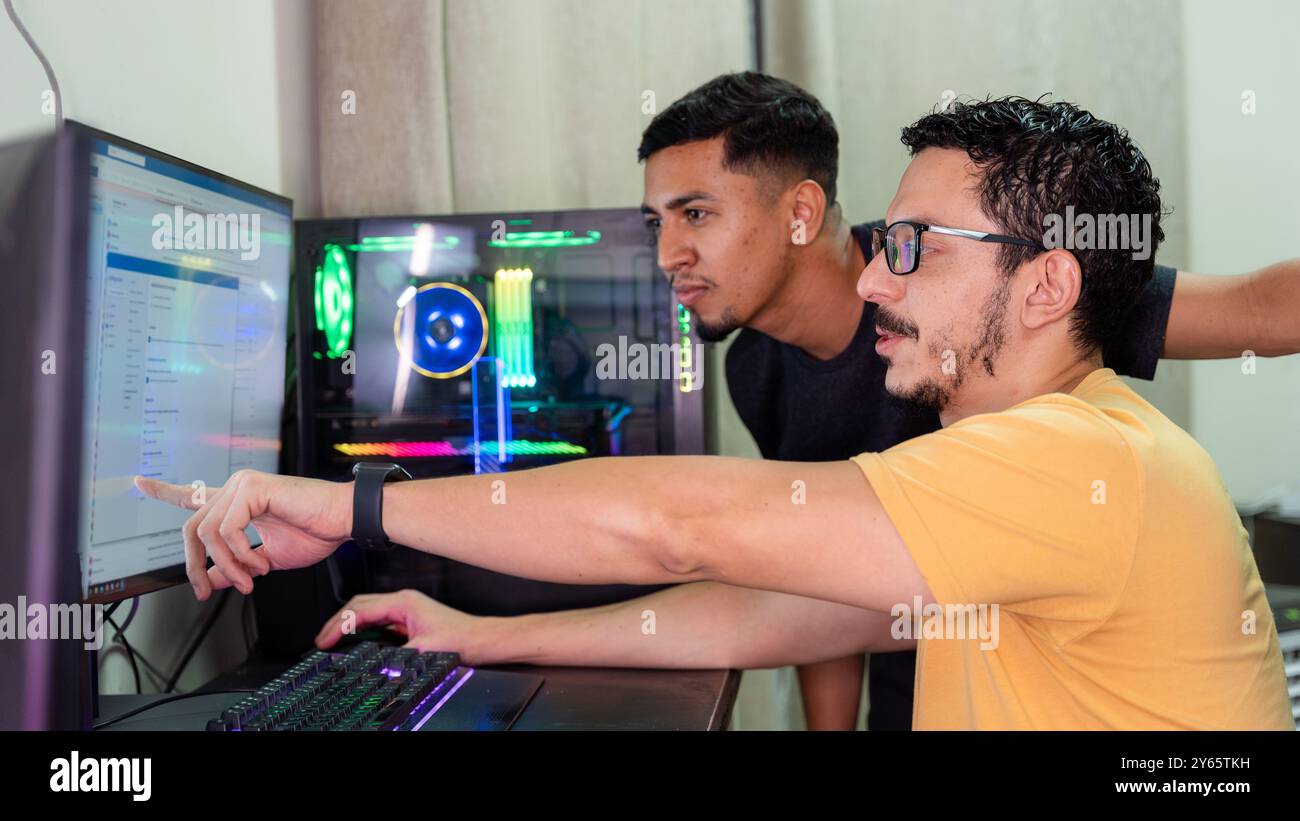 A gay couple engaging with software on a computer screen, illustrating ...