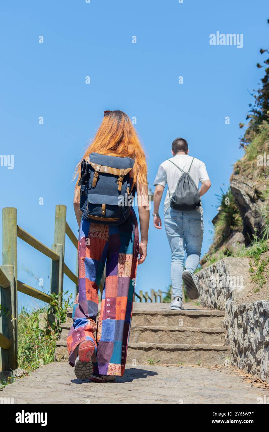 Back view of unrecognizable male and female hikers climbing stone steps ...