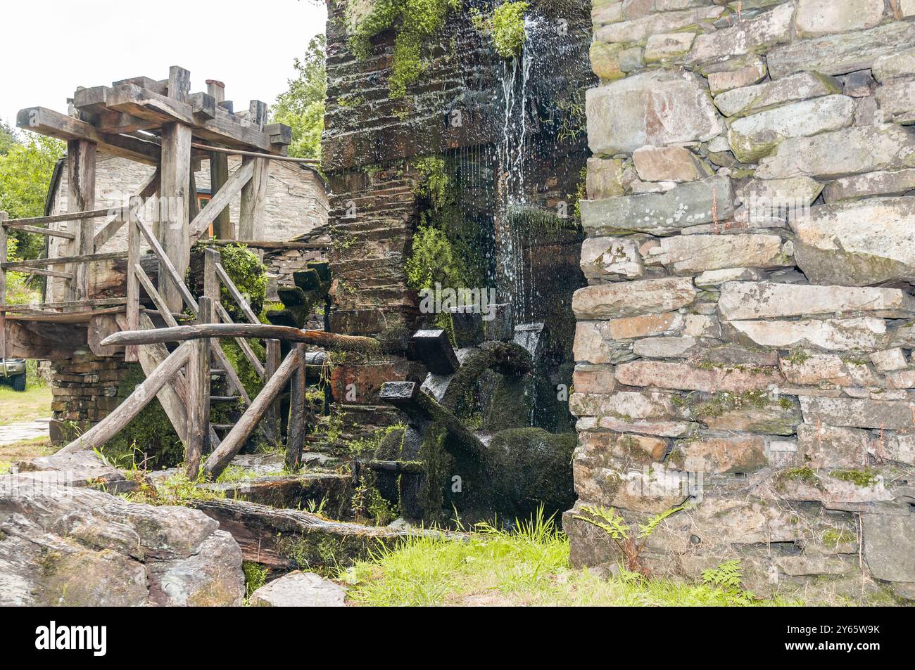 This image displays an old water mill with a detailed view of its ...