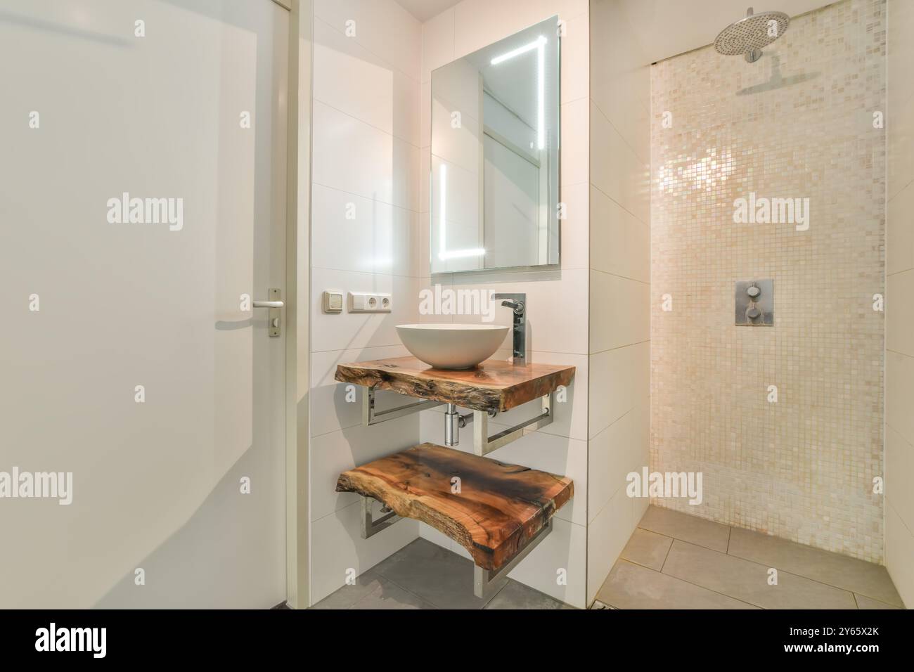 An elegantly designed modern bathroom featuring a natural wood vanity ...