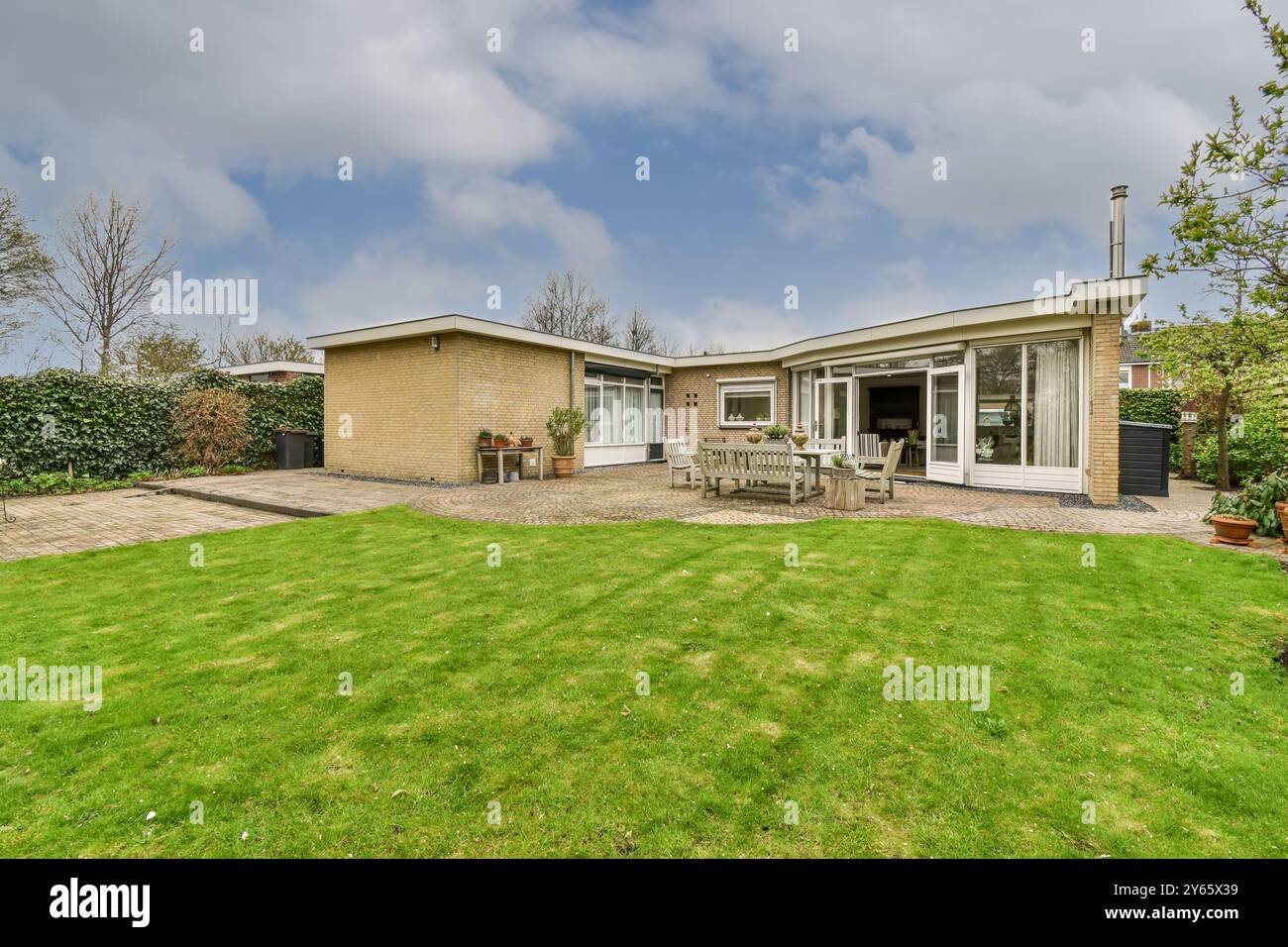 Modern single-story suburban home featuring a well-manicured lawn, a ...