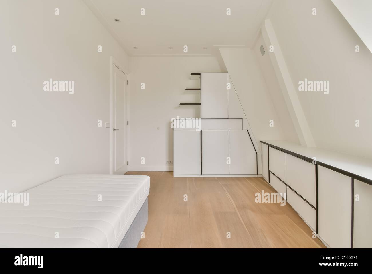 A bright minimalistic bedroom featuring a single bed and a sleek built ...