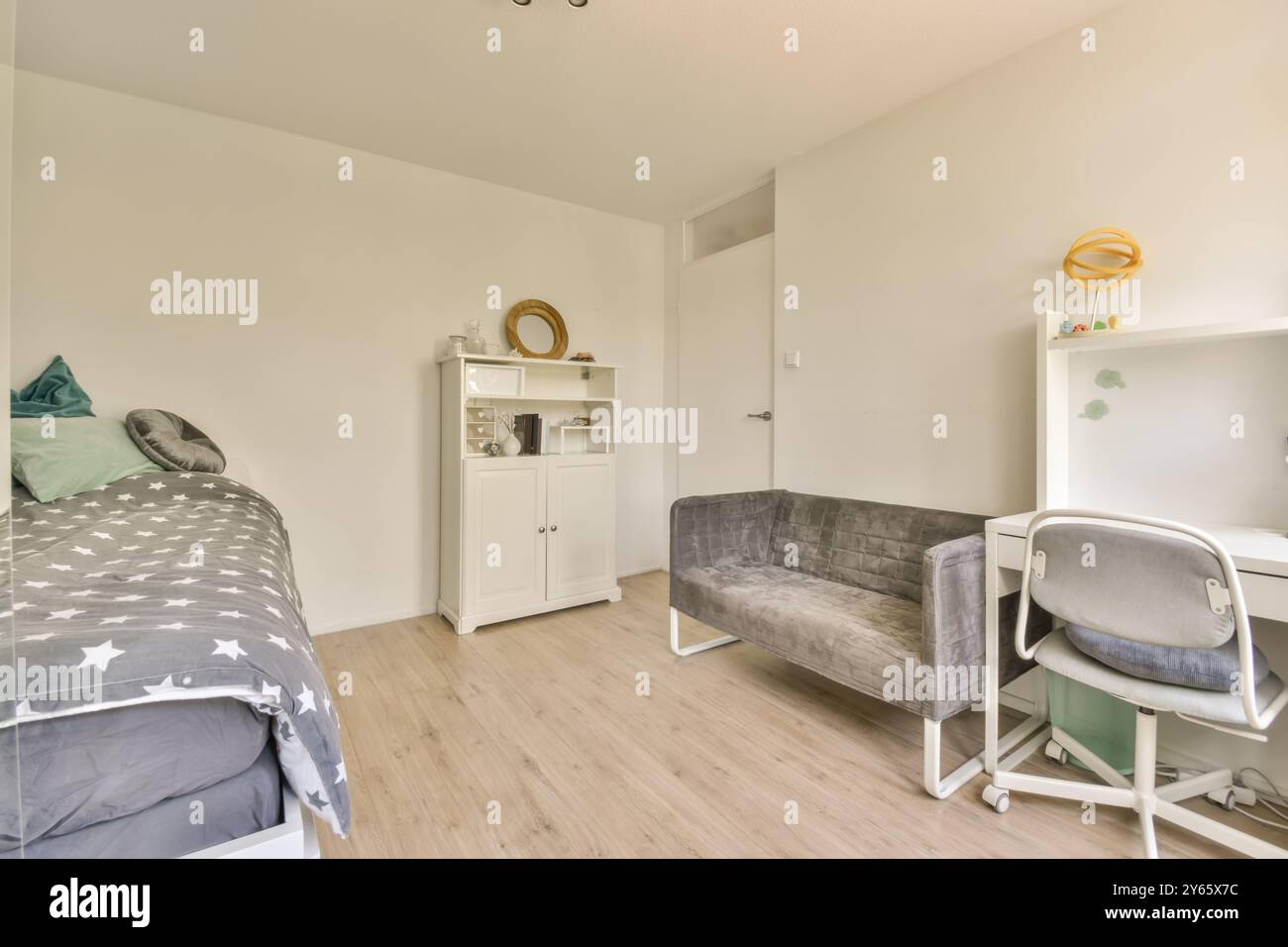 A bright teenager's bedroom featuring a star-patterned bed cover, a ...