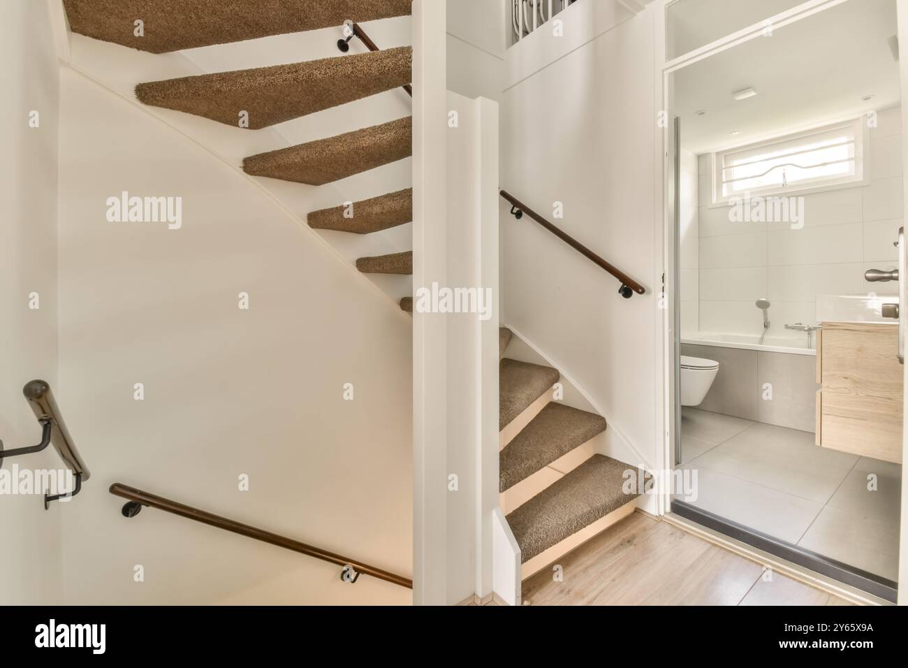 A well-lit interior space of a modern home featuring a staircase with ...