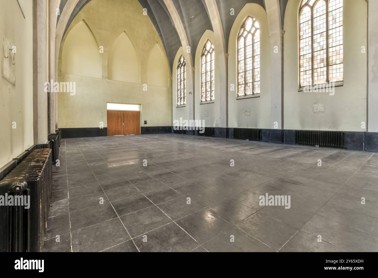 A vast, empty room displaying Gothic architecture with tall arched ...