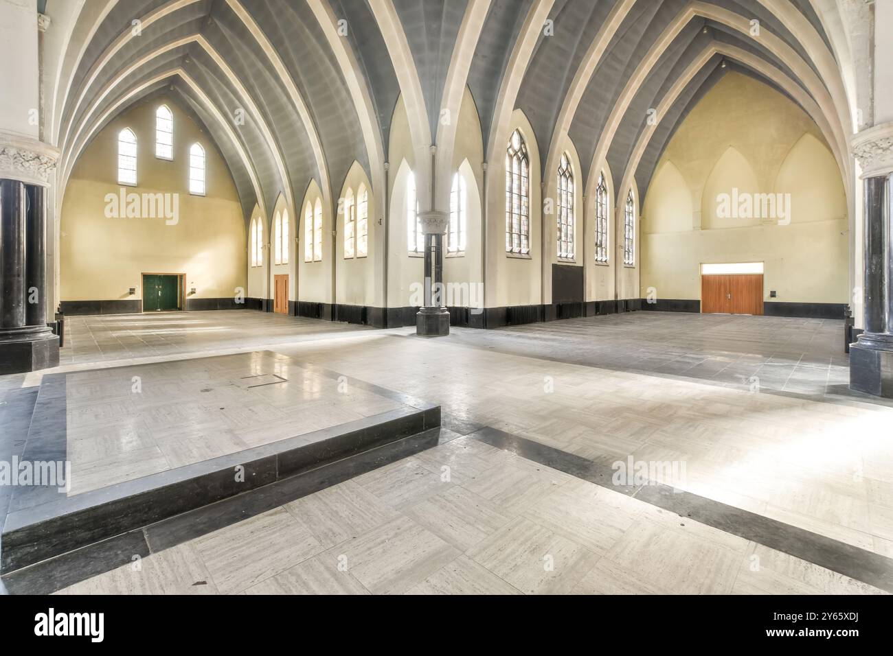 An expansive, sunlit interior of a gothic-style hall, with vaulted ...