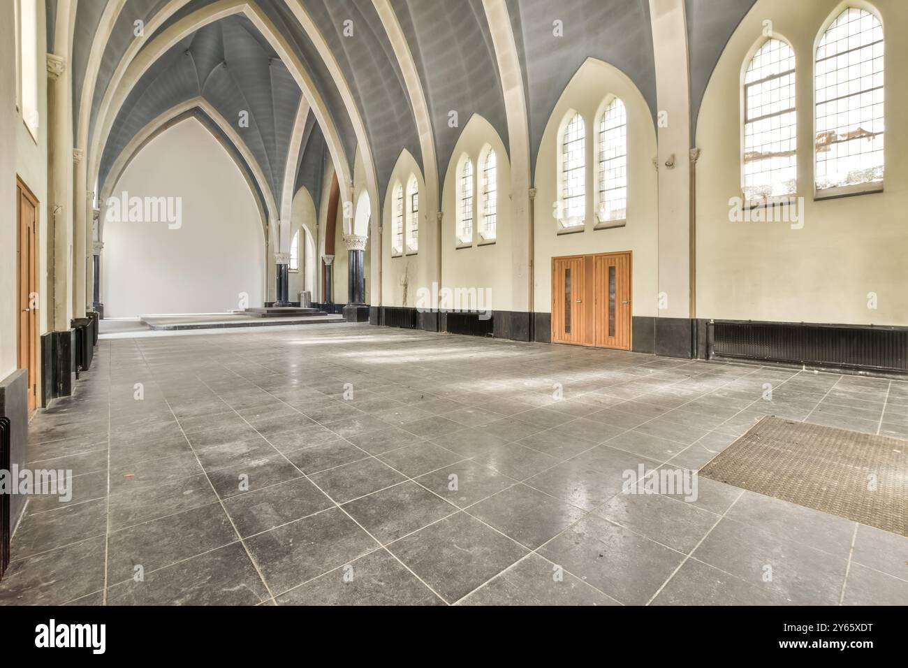 A vast and empty church interior with high arched ceilings, tiled ...