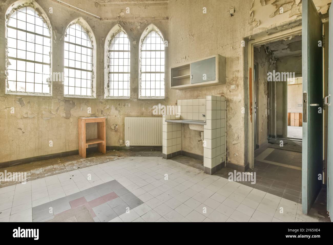 An interior view of a dilapidated and empty room with arched windows ...